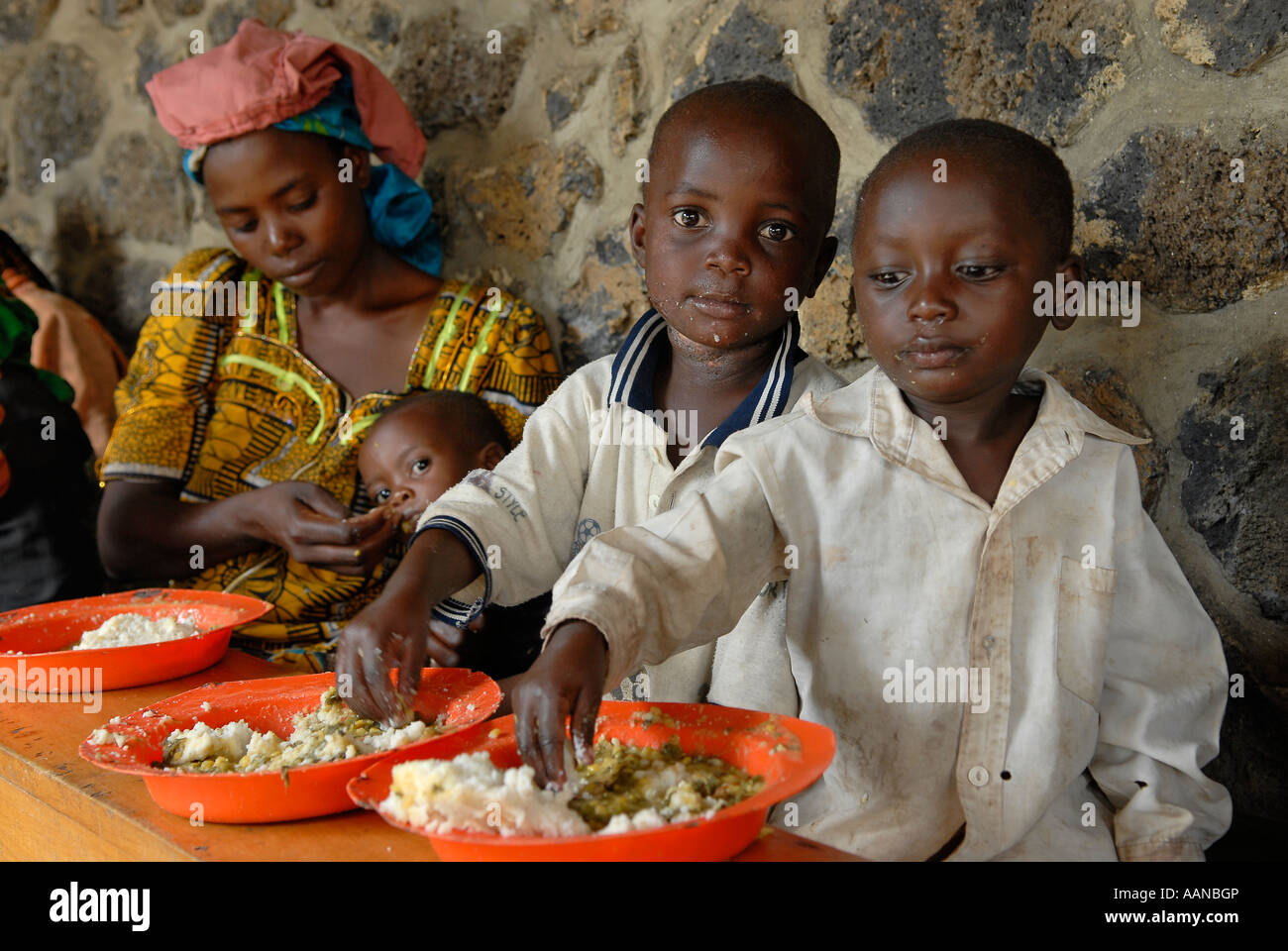 Displaced Congolese children eat mashed cassava with their hands at a ...