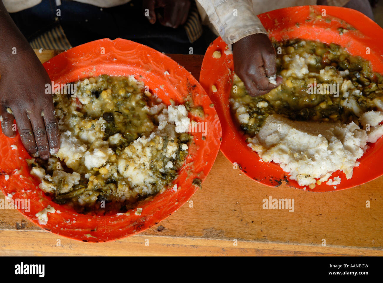 Displaced Congolese children eat mashed cassava at a feeding center run ...