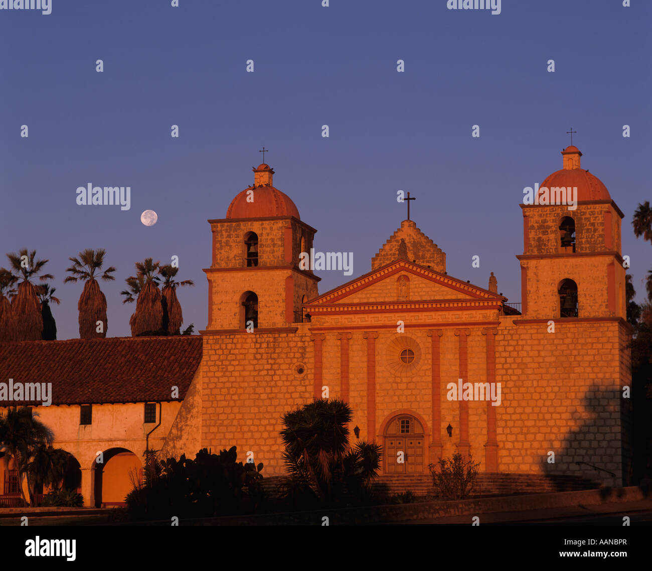 Santa Barbara Mission at sunrise with moonsetting with warm light on ...