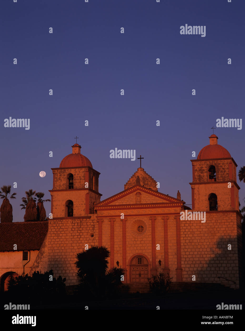 Santa Barbara Mission at sunrise with moonsetting with warm light on ...