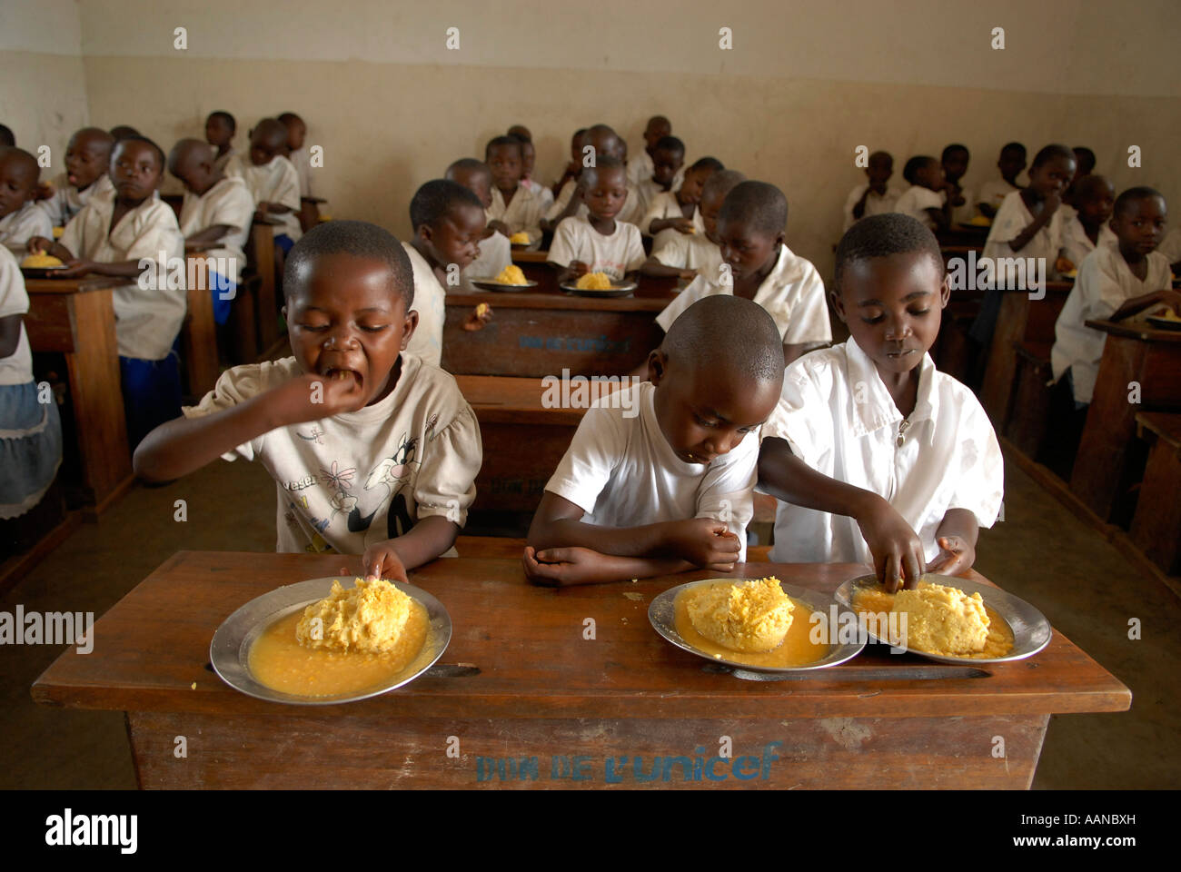 Schoolchildren eat with their hands at lunch time in a primary ...