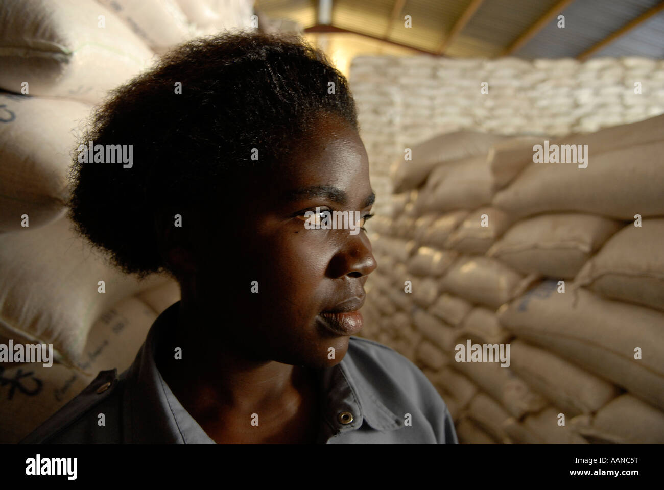 An employee of World Food Programme WFP stands amid large sacks of ...