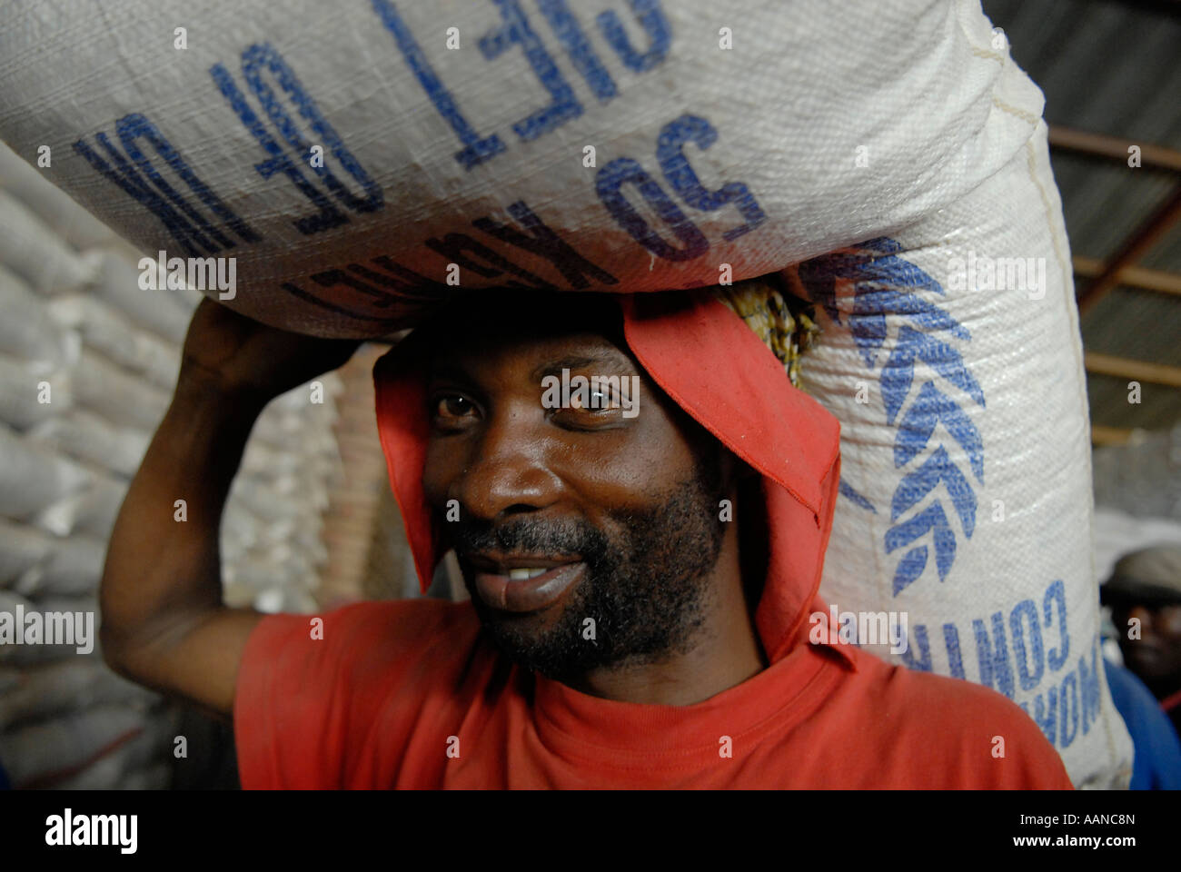 Man carries large sack of corn soya blend at World Food Programme WFP ...