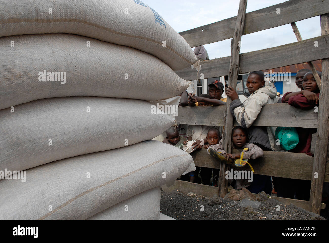 Internally displaced people wait to receive sacks containing corn soya ...