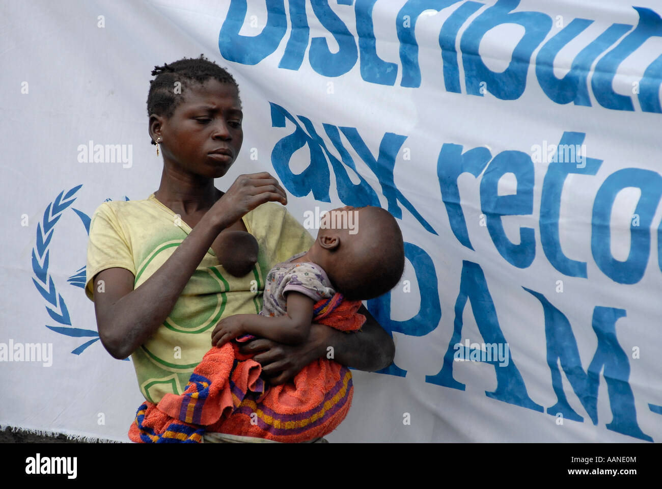Displaced Congolese woman holds her child as she waits food ...