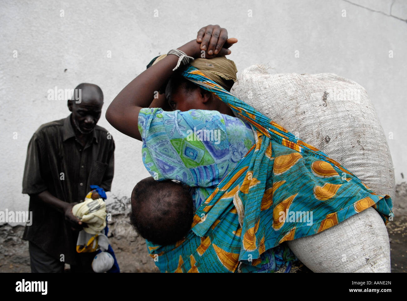 An Internally displaced woman carries large sack of corn soya blend ...