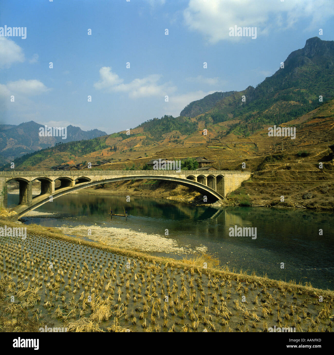 Arched bridge spanning a river landscape and rice paddies in the ...