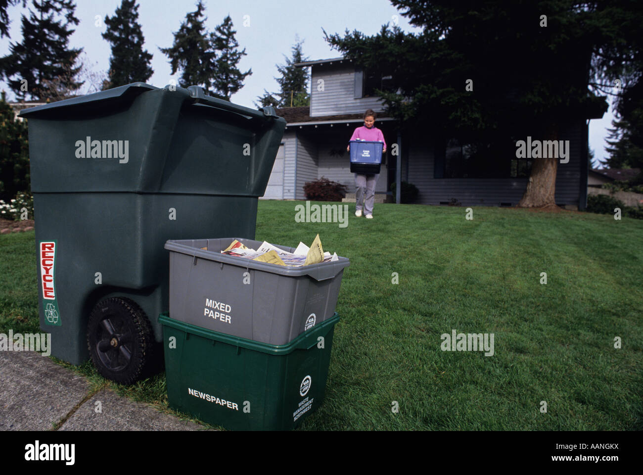 Retro image of Woman carrying recycling bin to curb for curbside ...