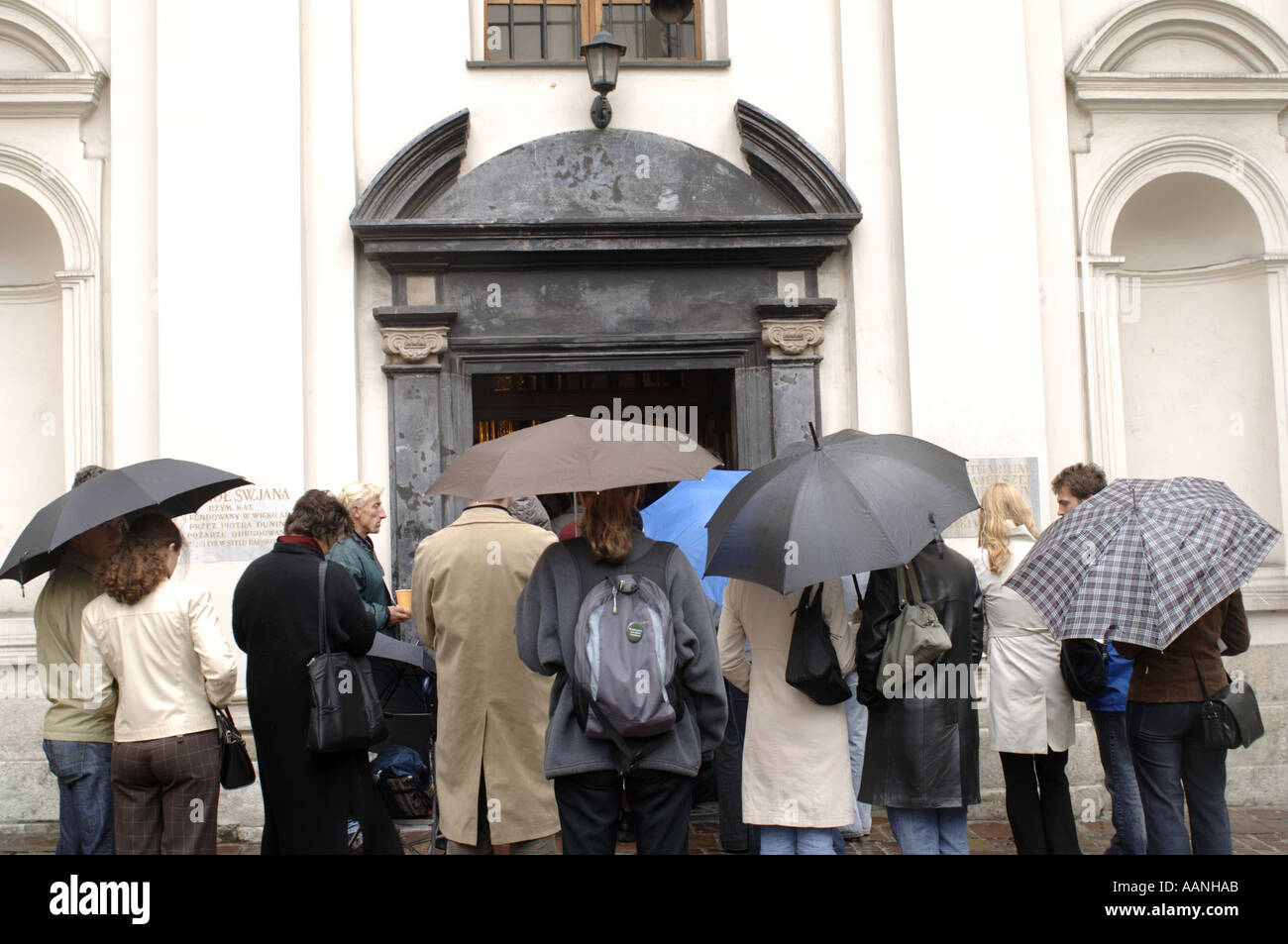 A church congregation standing in the rain spilling out into the street ...