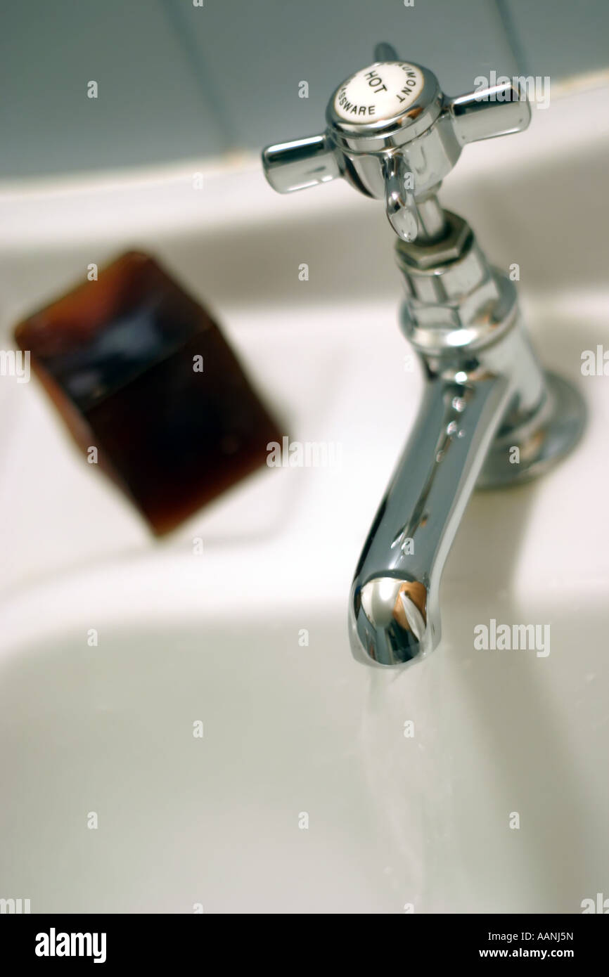 close up shot of water running from old fashioned type of tap faucet ...