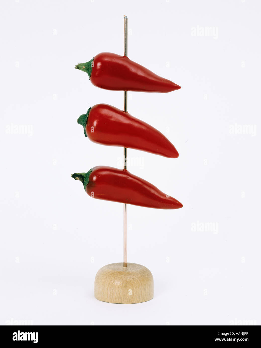 Three chilli peppers on wire receipt spike on white background Stock ...
