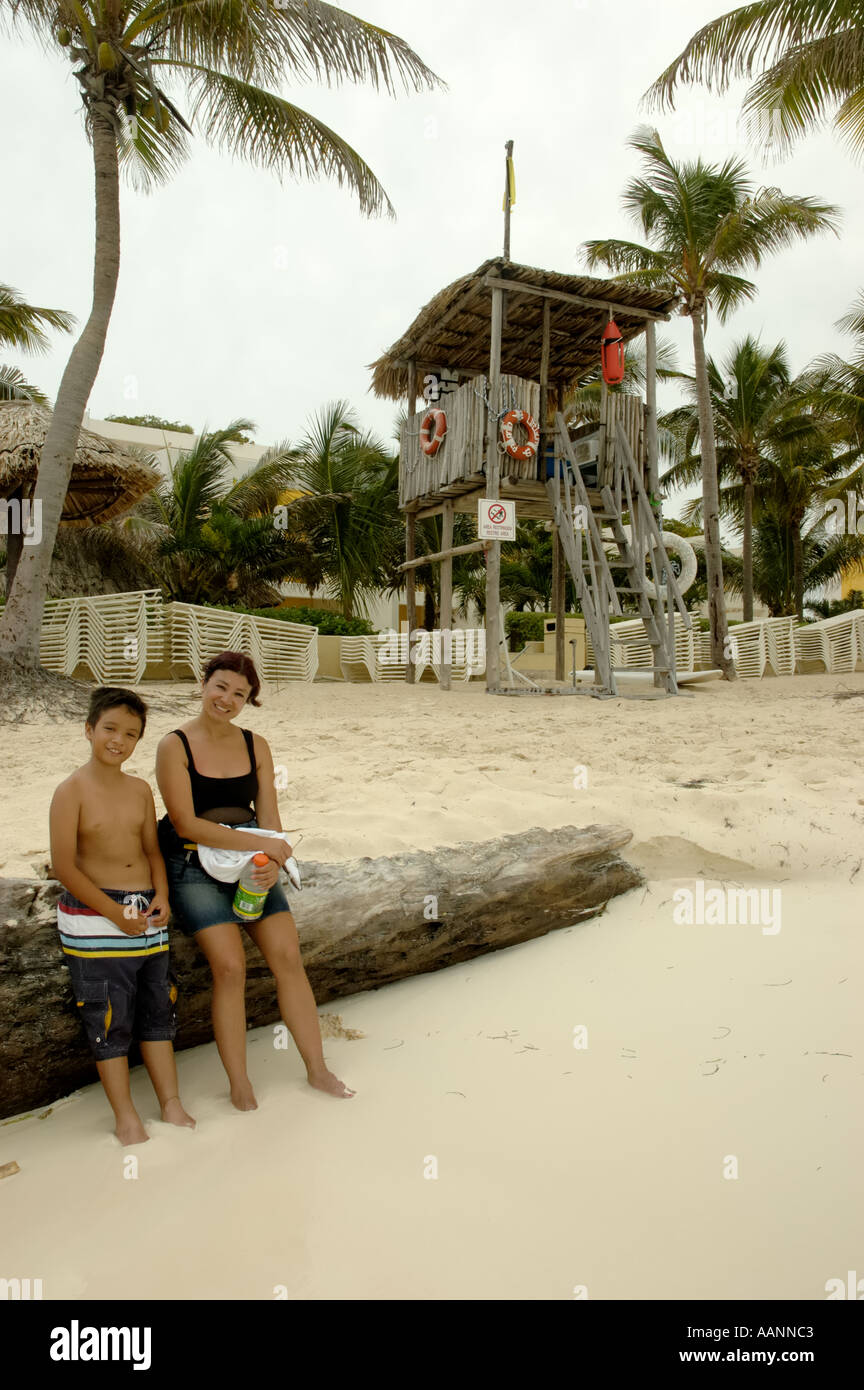 Mother and son at the beach sitting on a log on the sand Lifeguard ...