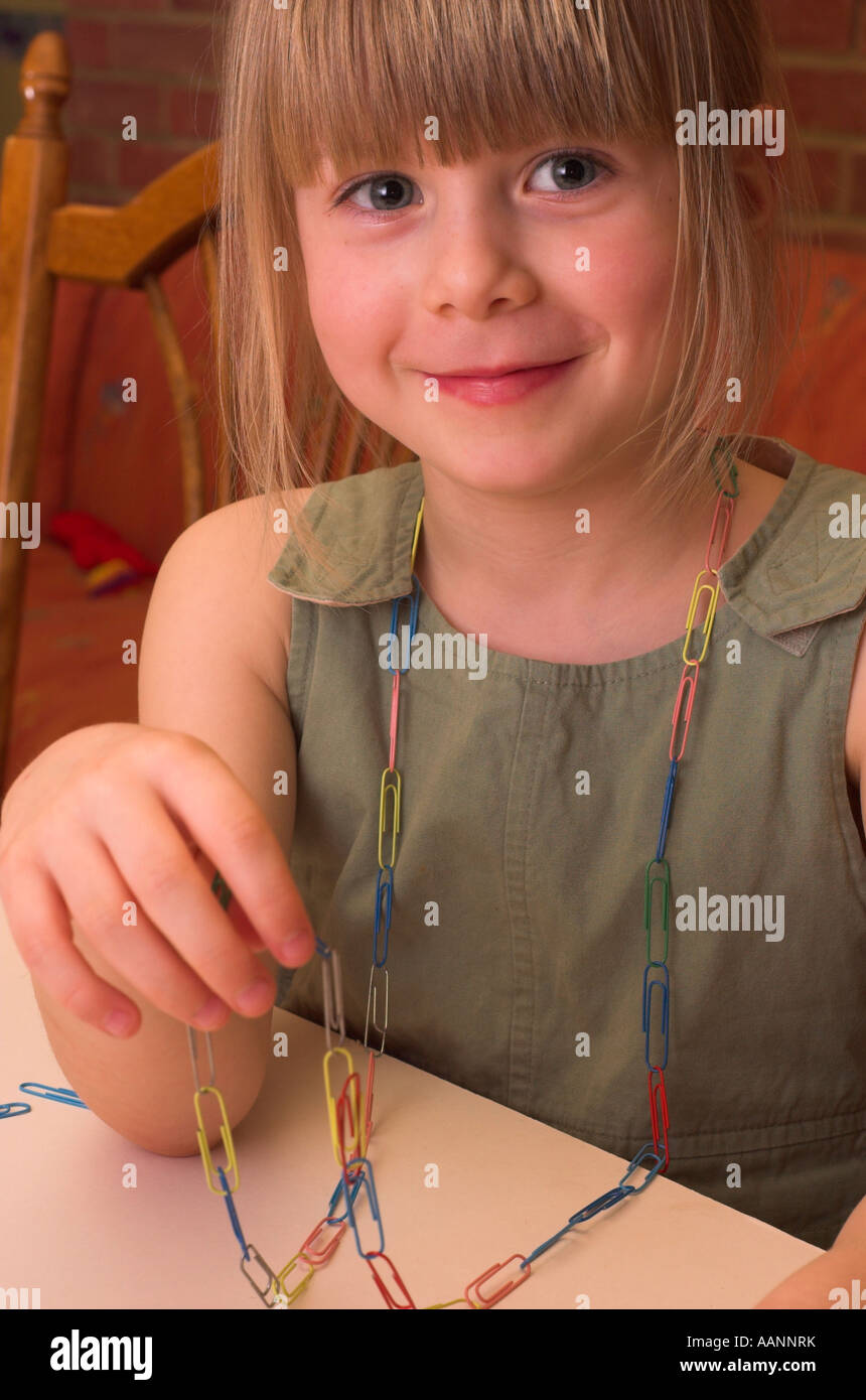 Young child 4 5 making a chain out of paper clips Stock Photo - Alamy