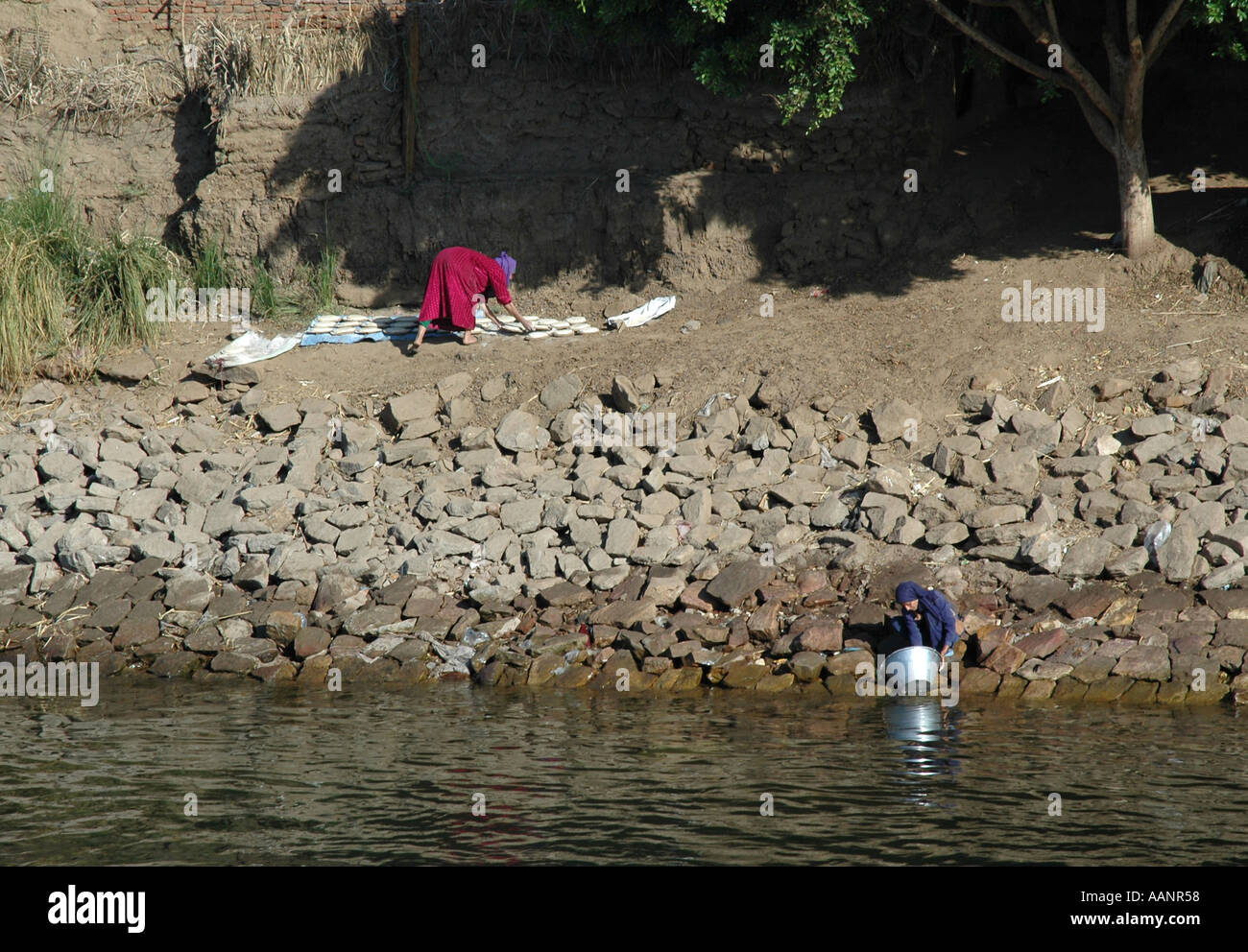 Washing cooking bowls on the banks of the River Nile Egypt Stock Photo ...