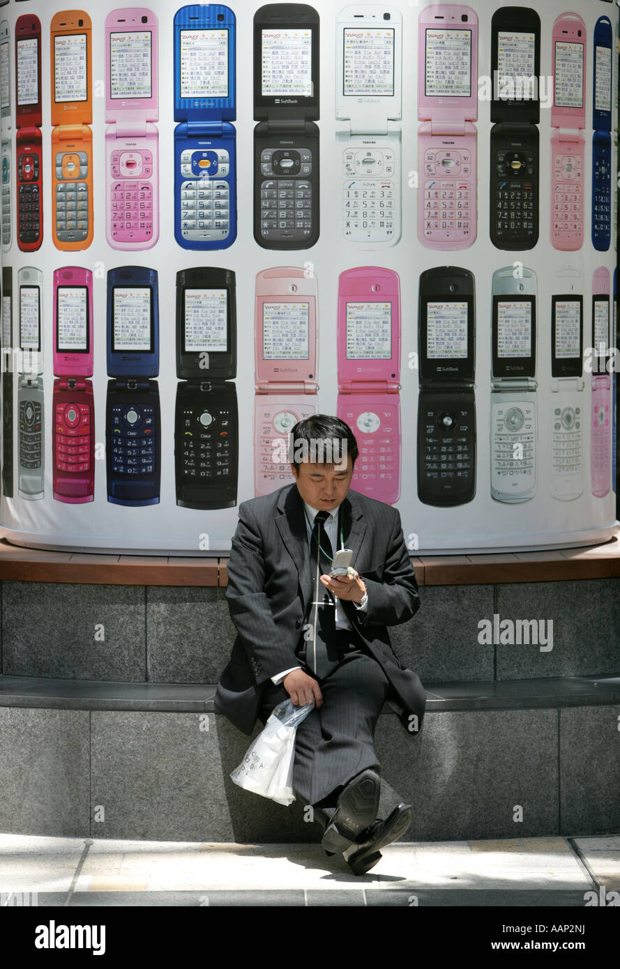 JPN, Japan, Tokyo: Mobile phone user. Billboard of japanese provider ...