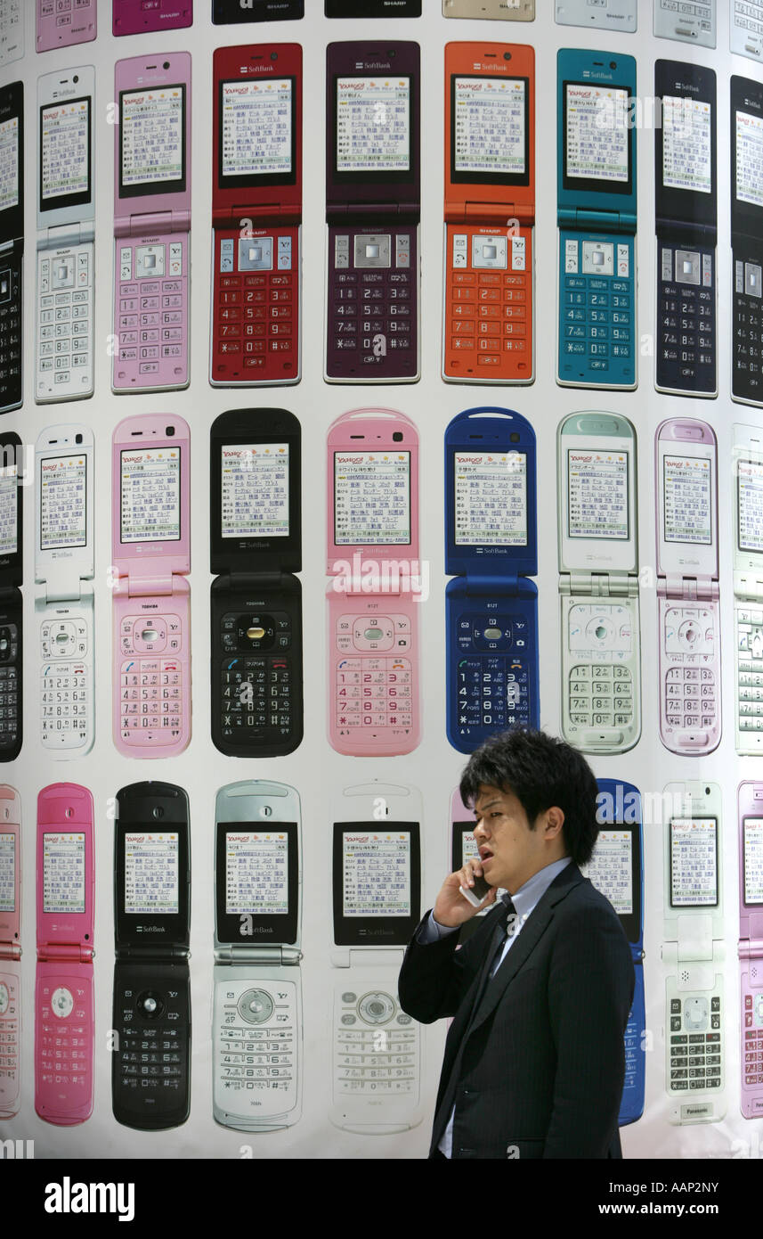 JPN, Japan, Tokyo: Mobile phone user. Billboard of japanese provider ...