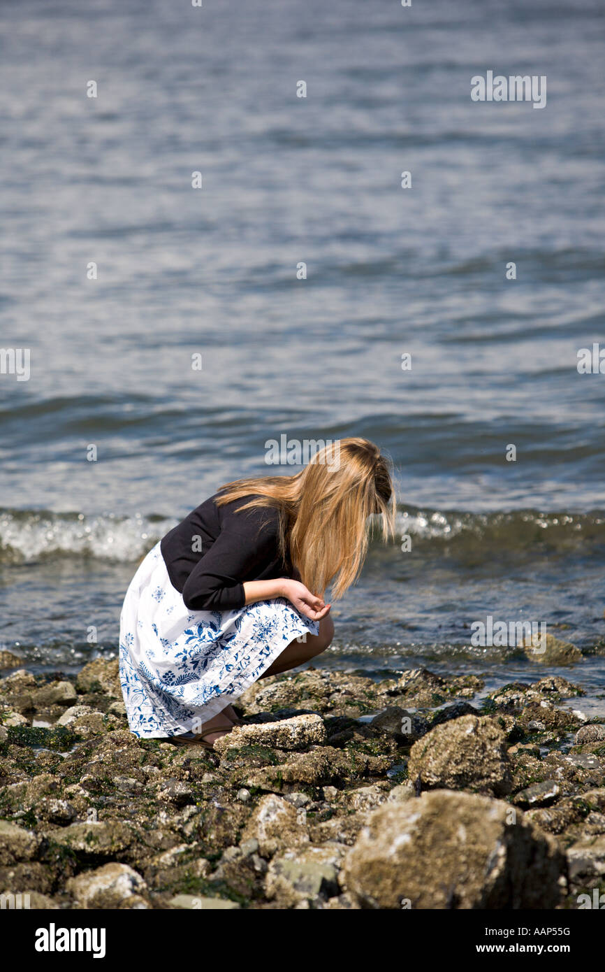 Young woman explores tide pools at Alki Beach in Seattle WA Stock Photo ...