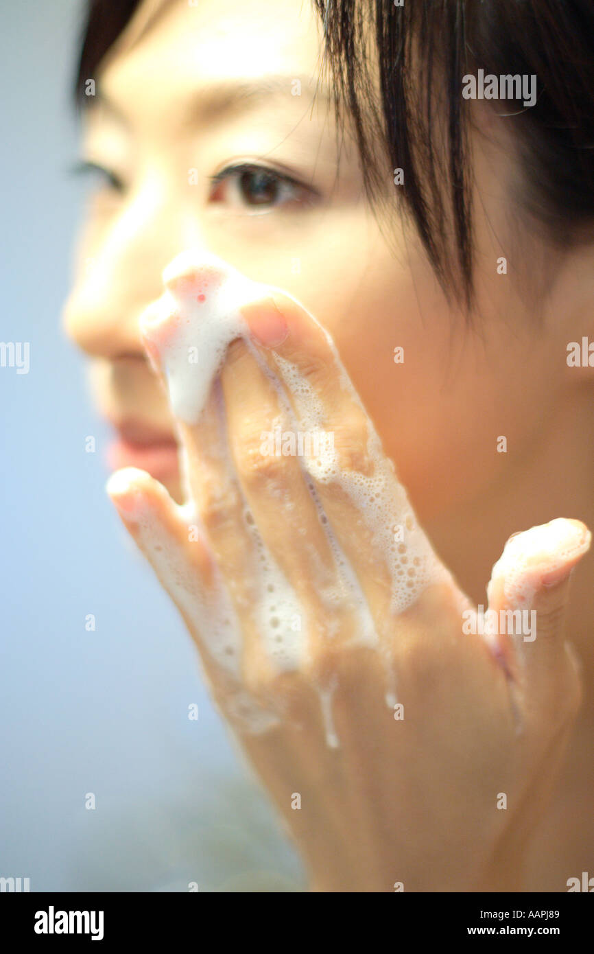 Close-up of a young woman washing face with soap Stock Photo - Alamy