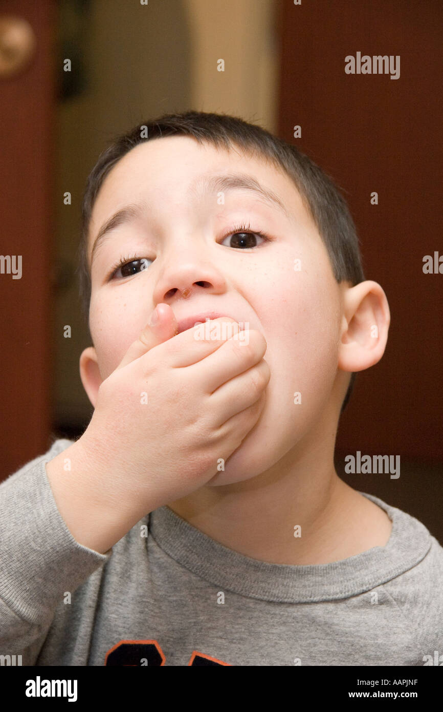 Four year old boy eating with hands Stock Photo - Alamy