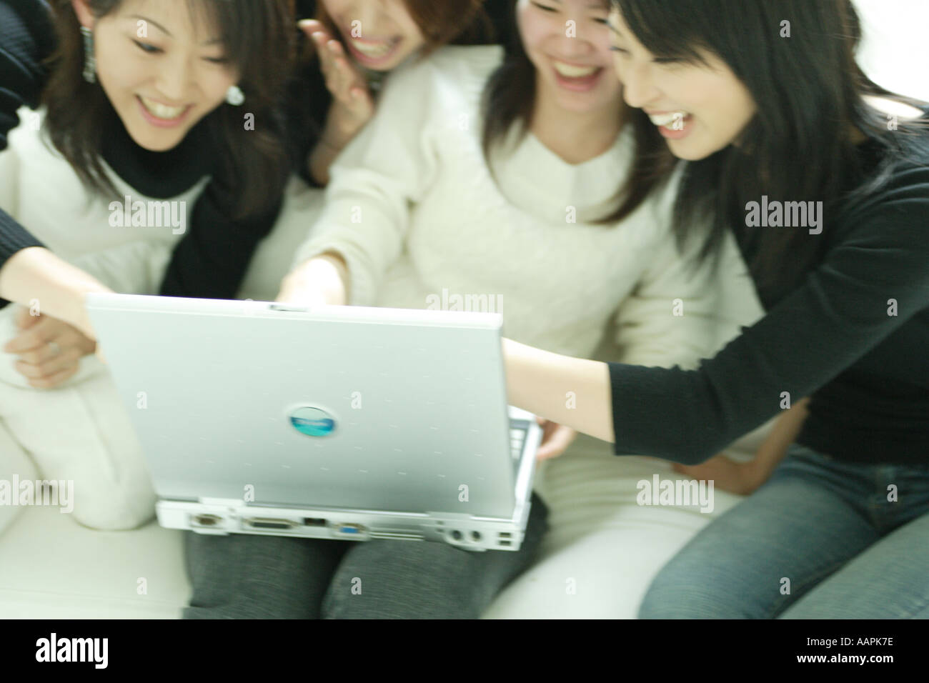 Four young woman looking at computer Stock Photo - Alamy