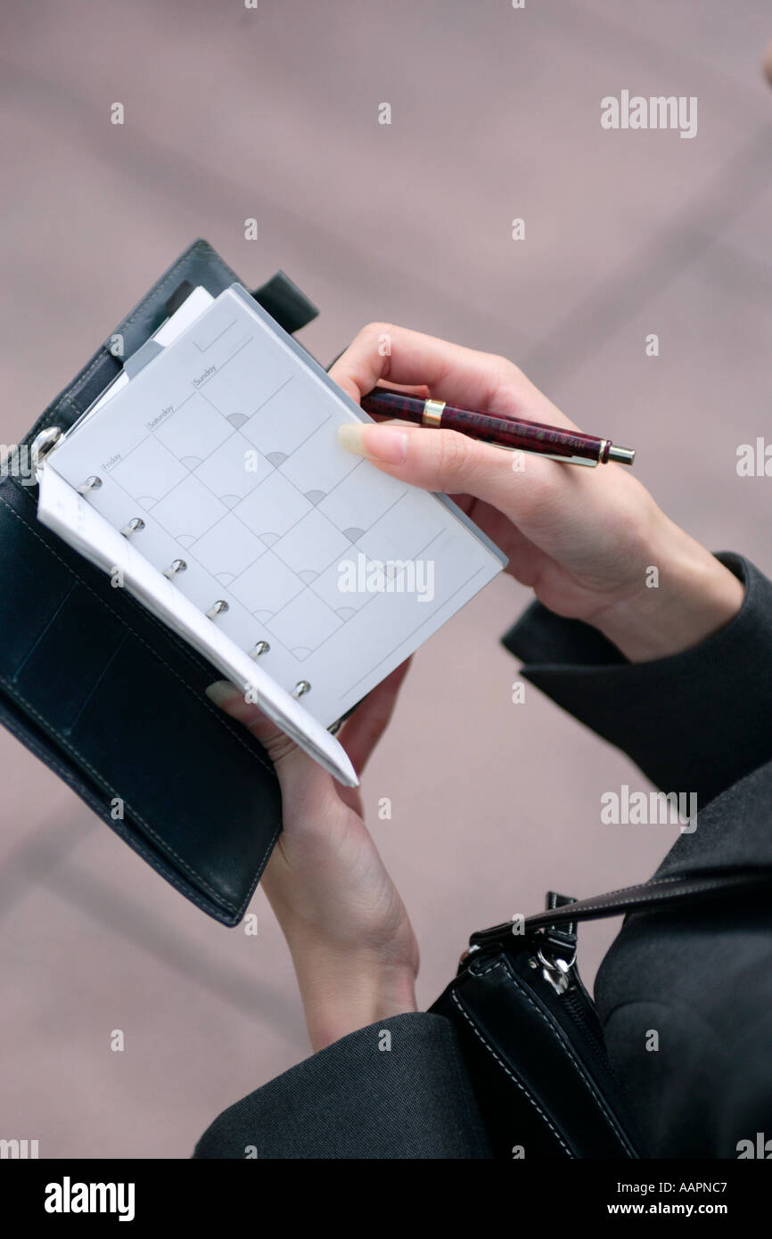 A young woman checking schedule, close-up Stock Photo - Alamy