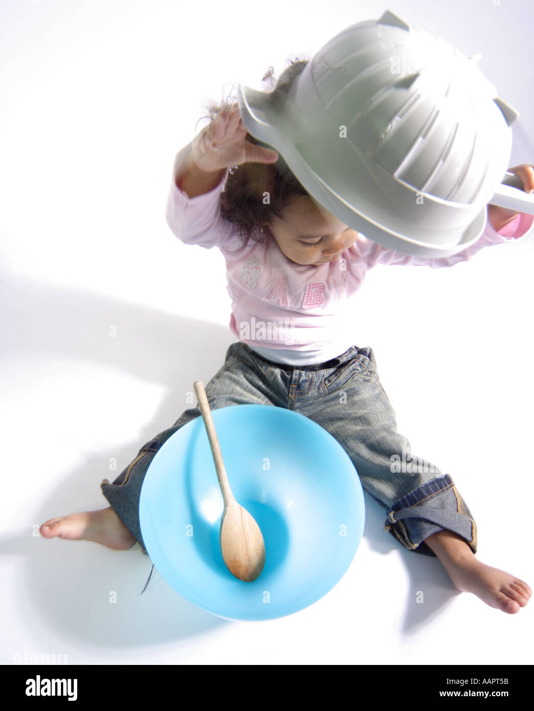 Aerial view of young baby toddler playing with mothers kitchen utensils ...