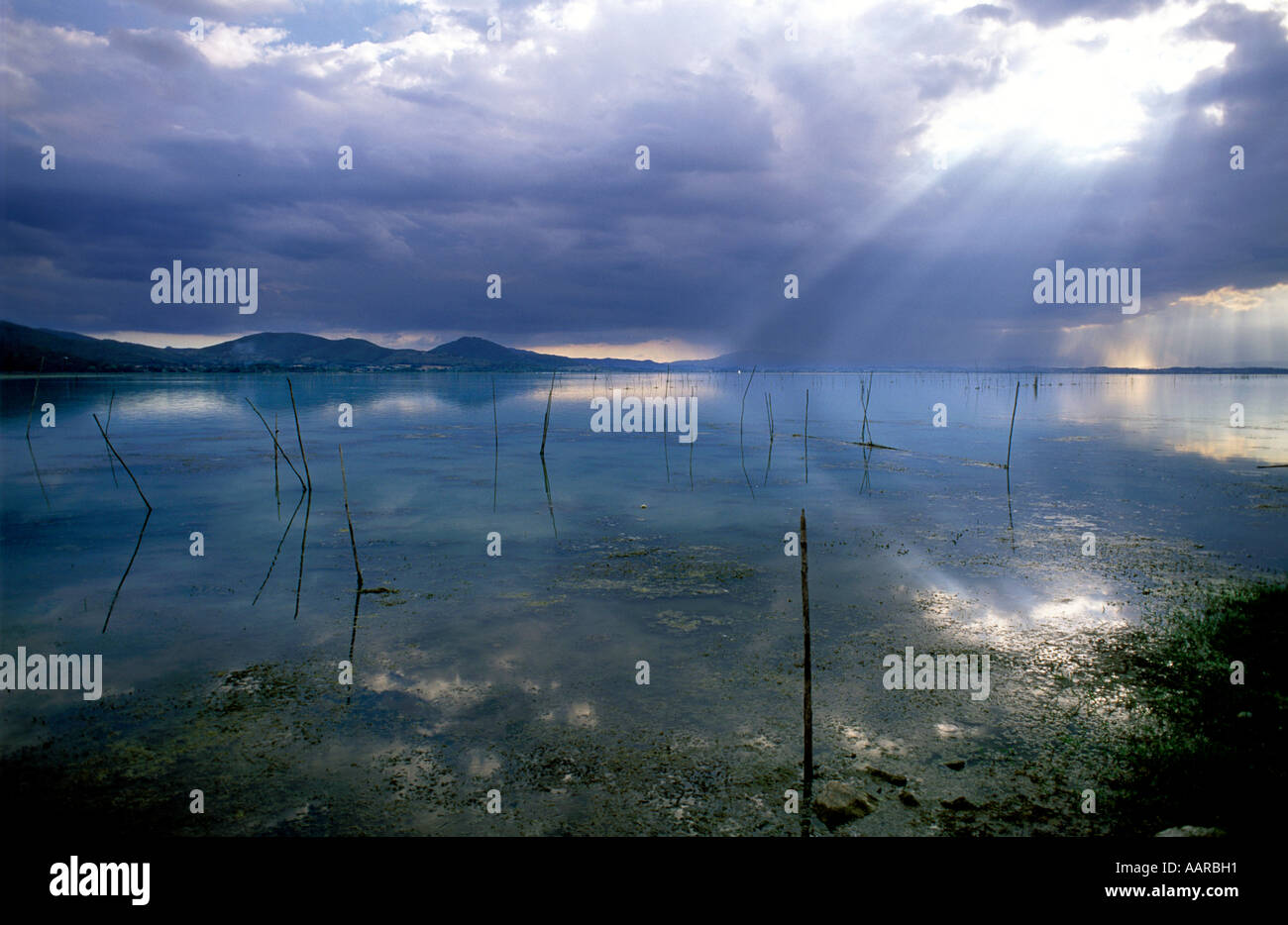 Sun shining through storm clouds on Lake Trasimeno, Umbria, Italy Stock ...