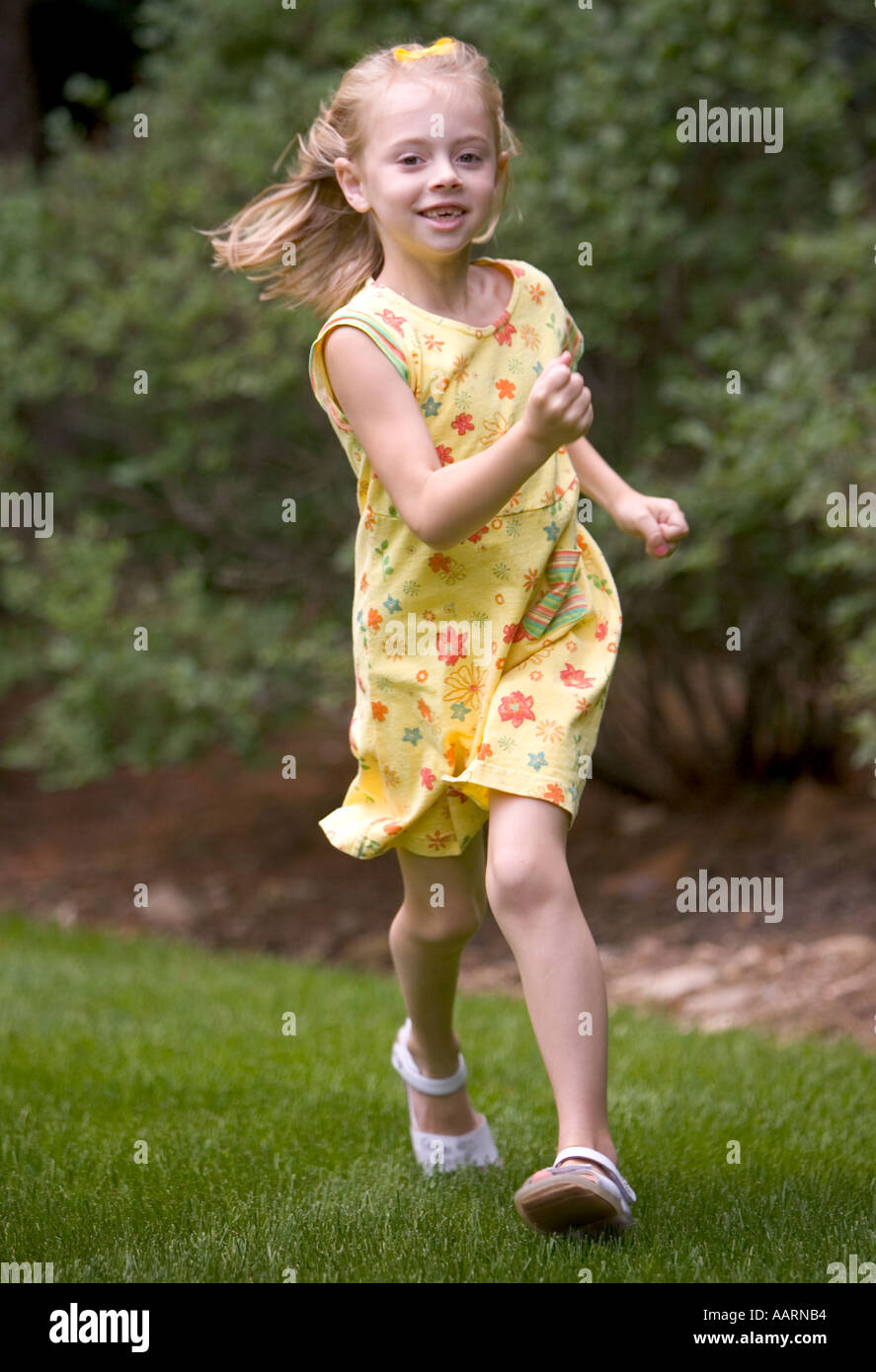 Young girl running in the backyard Stock Photo - Alamy