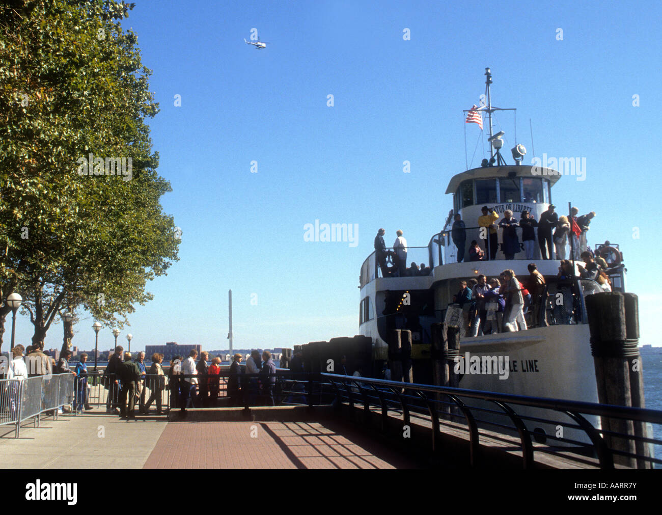 Tourists Boarding A Battery Park Ferry In NYC.Which Takes People To ...