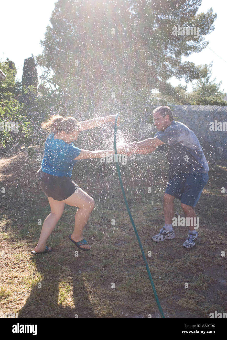 Water fight in a garden, young couple Stock Photo - Alamy