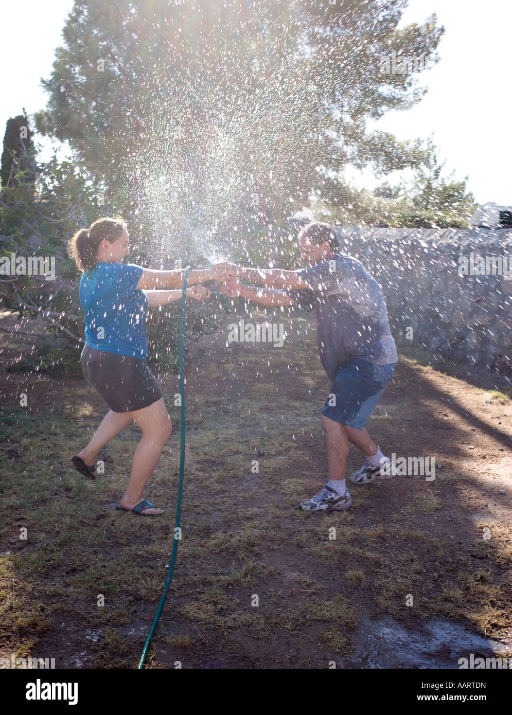 Water fight in a garden, young couple Stock Photo - Alamy