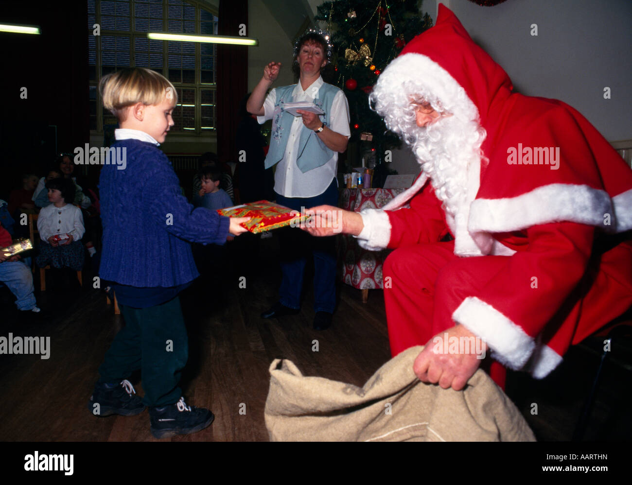 Father Christmas Handing Out Presents from a Sack At Nursery School ...