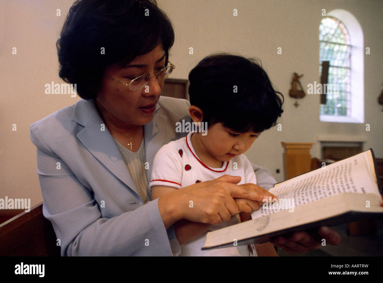 Korean Mother Reading Bible To Korean Child in Church Stock Photo - Alamy