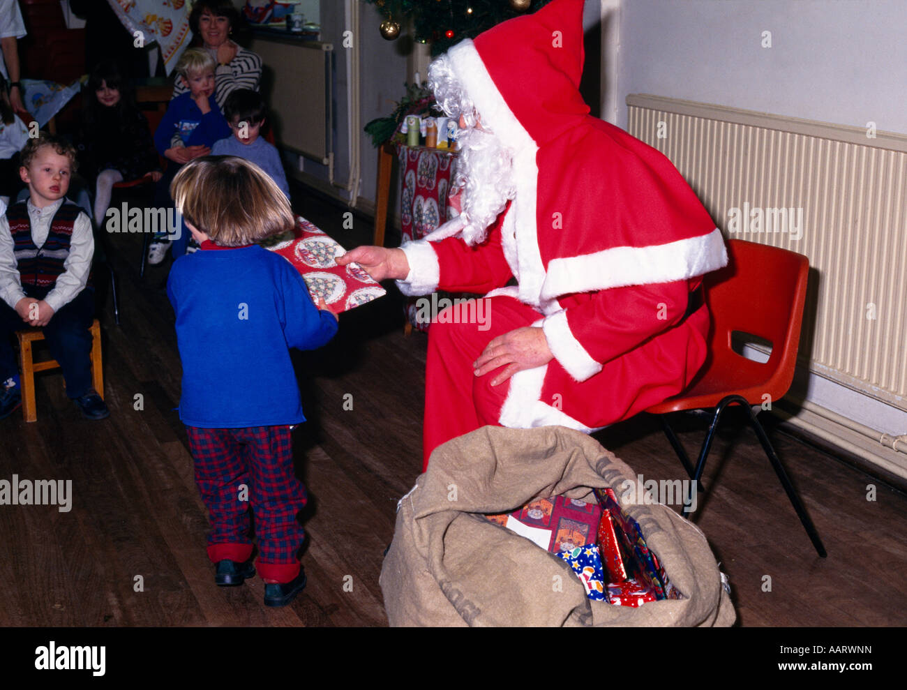 Father Christmas Giving Present At Kindergarten Stock Photo - Alamy