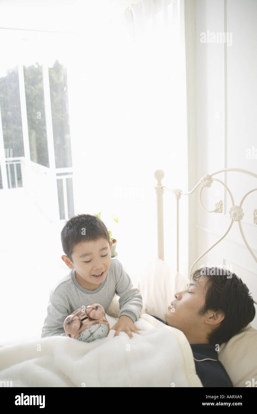 Son waking up father Stock Photo - Alamy