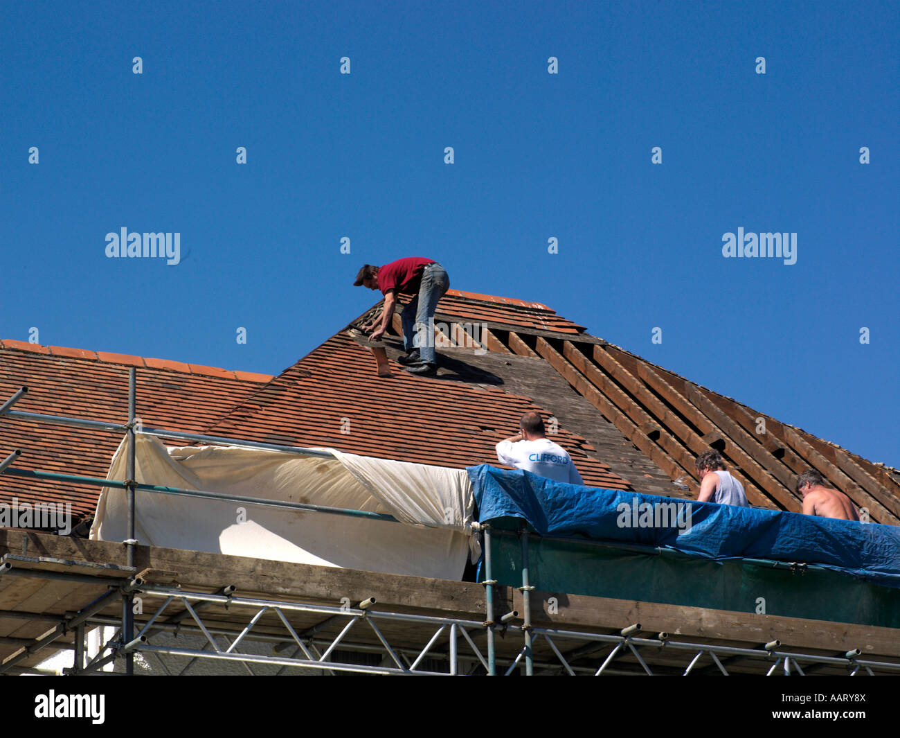 Workmen removing old tiles from roof of house hi-res stock photography ...