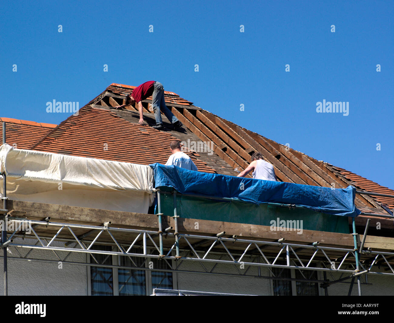Workmen removing old tiles from roof of house hi-res stock photography ...