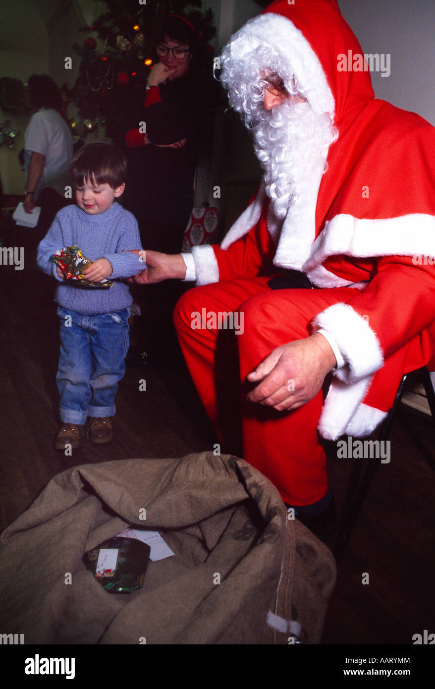 Father Christmas Handing Out Presents from a Sack At Nursery School ...