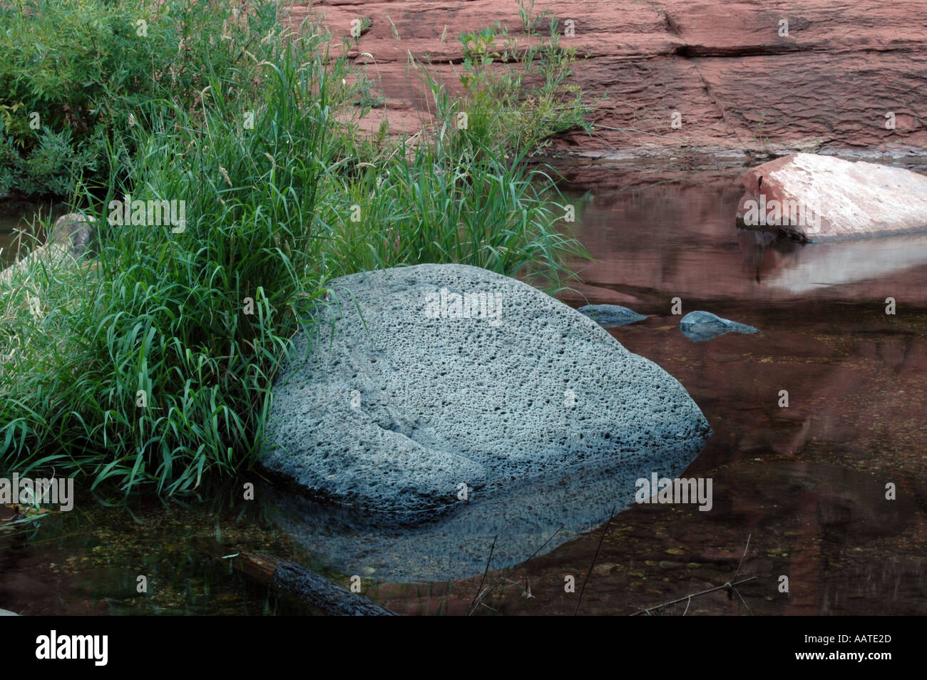 Single boulder partially submerged in calm stream Stock Photo - Alamy
