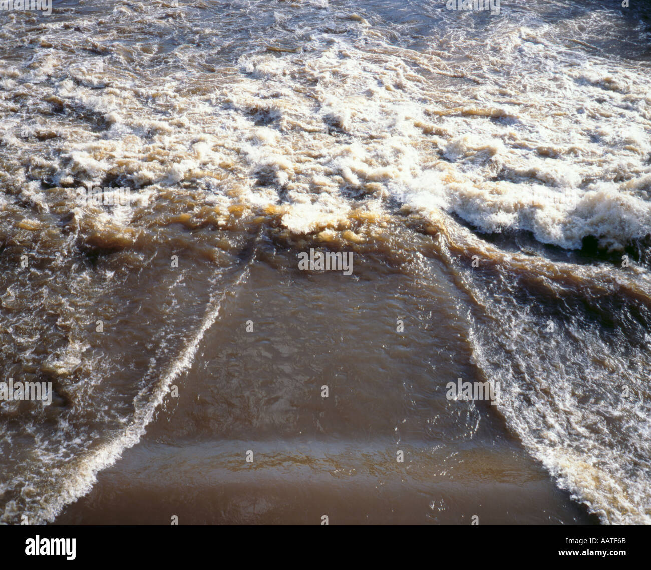 Flood water flowing over a concrete apron; River Tyne in flood beneath ...