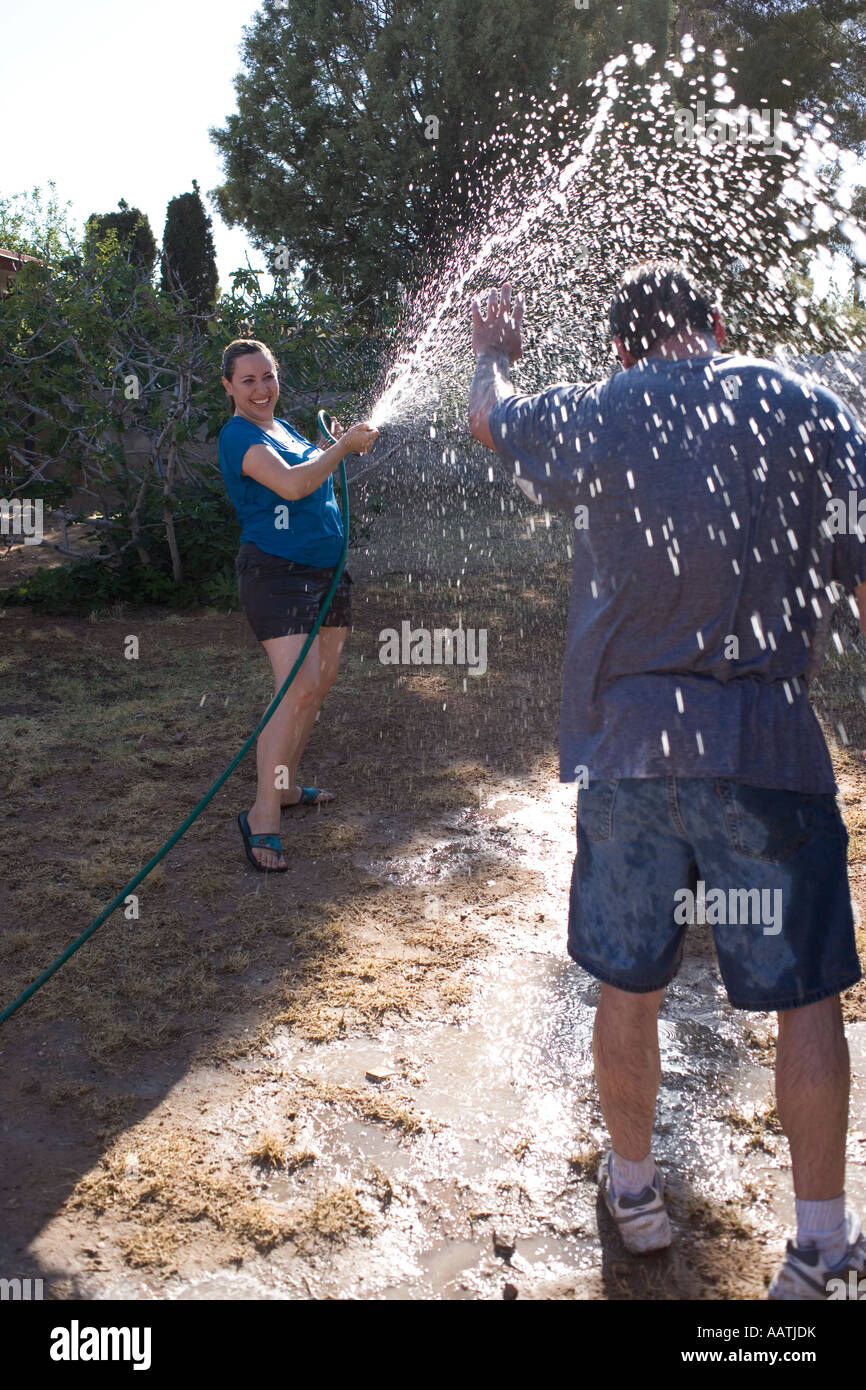 Water fight in a garden, young couple Stock Photo - Alamy