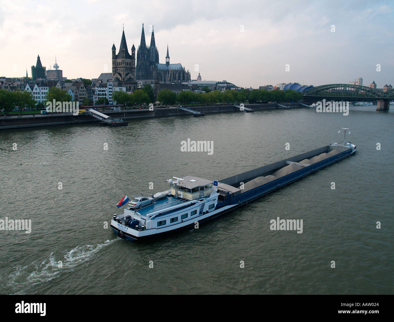 Dutch Rhine barge loaded with sand passing the center of Cologne ...