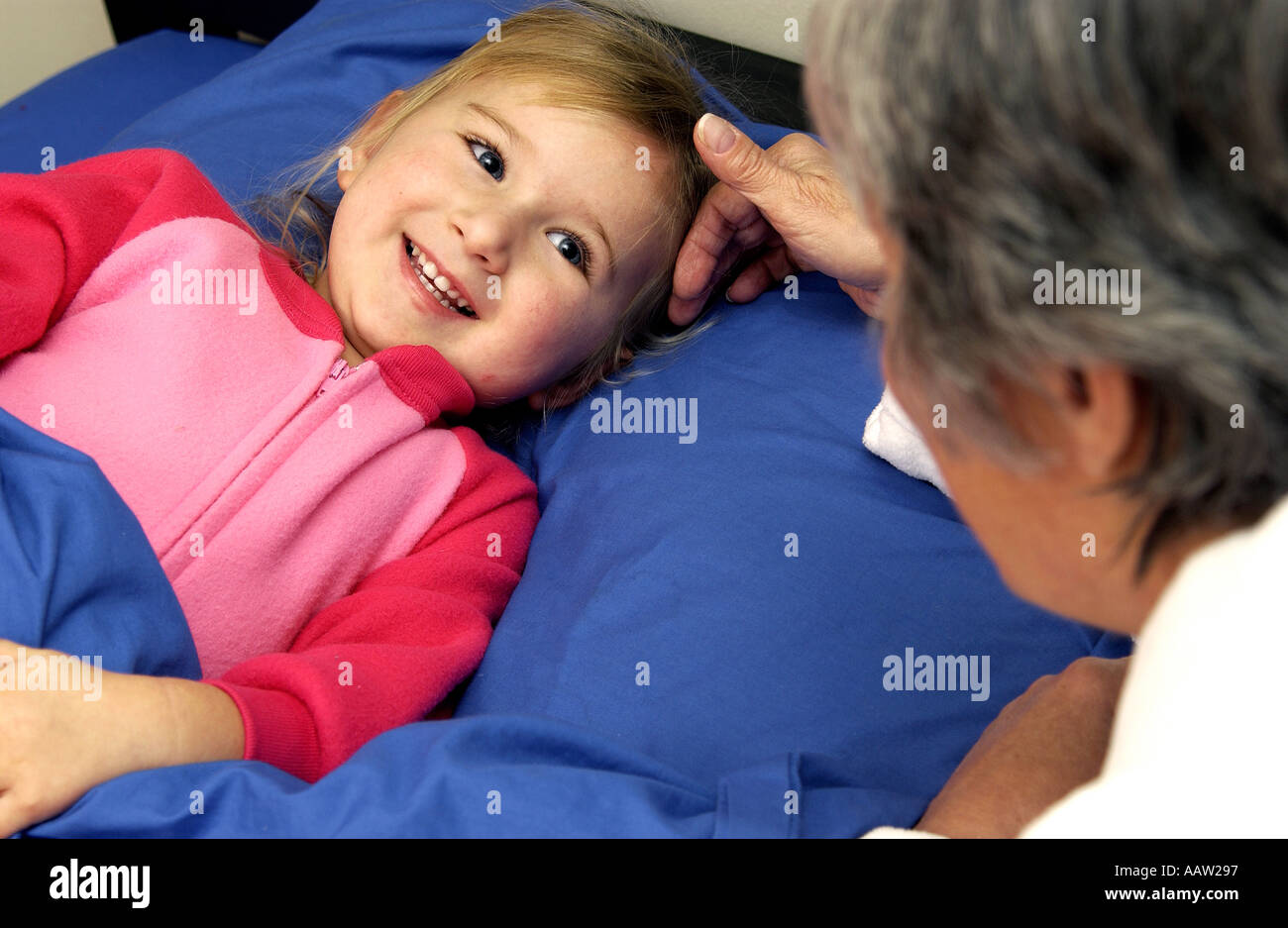 Grandma putting granddaughter to bed Stock Photo - Alamy