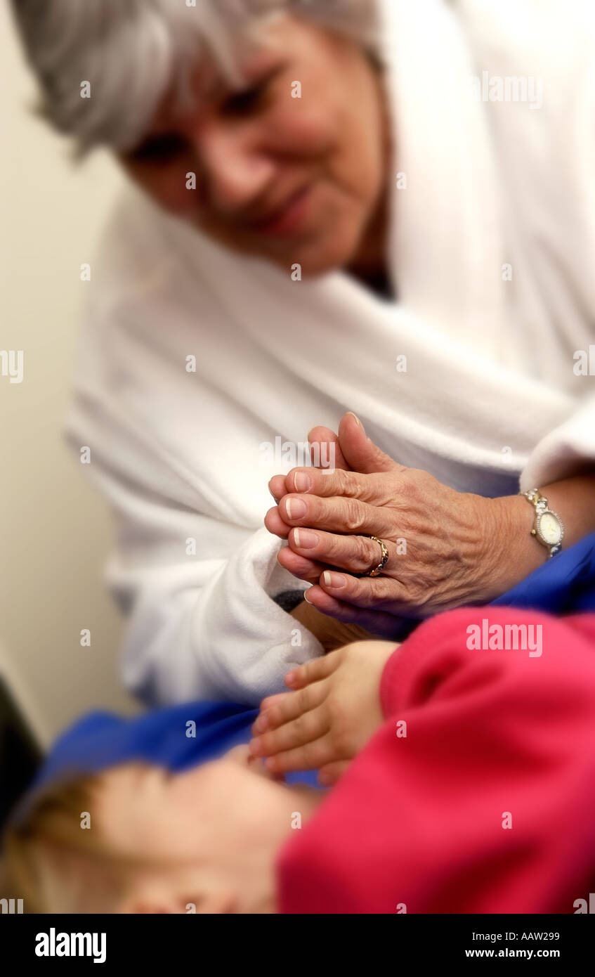Grandma putting granddaughter to bed praying Stock Photo - Alamy