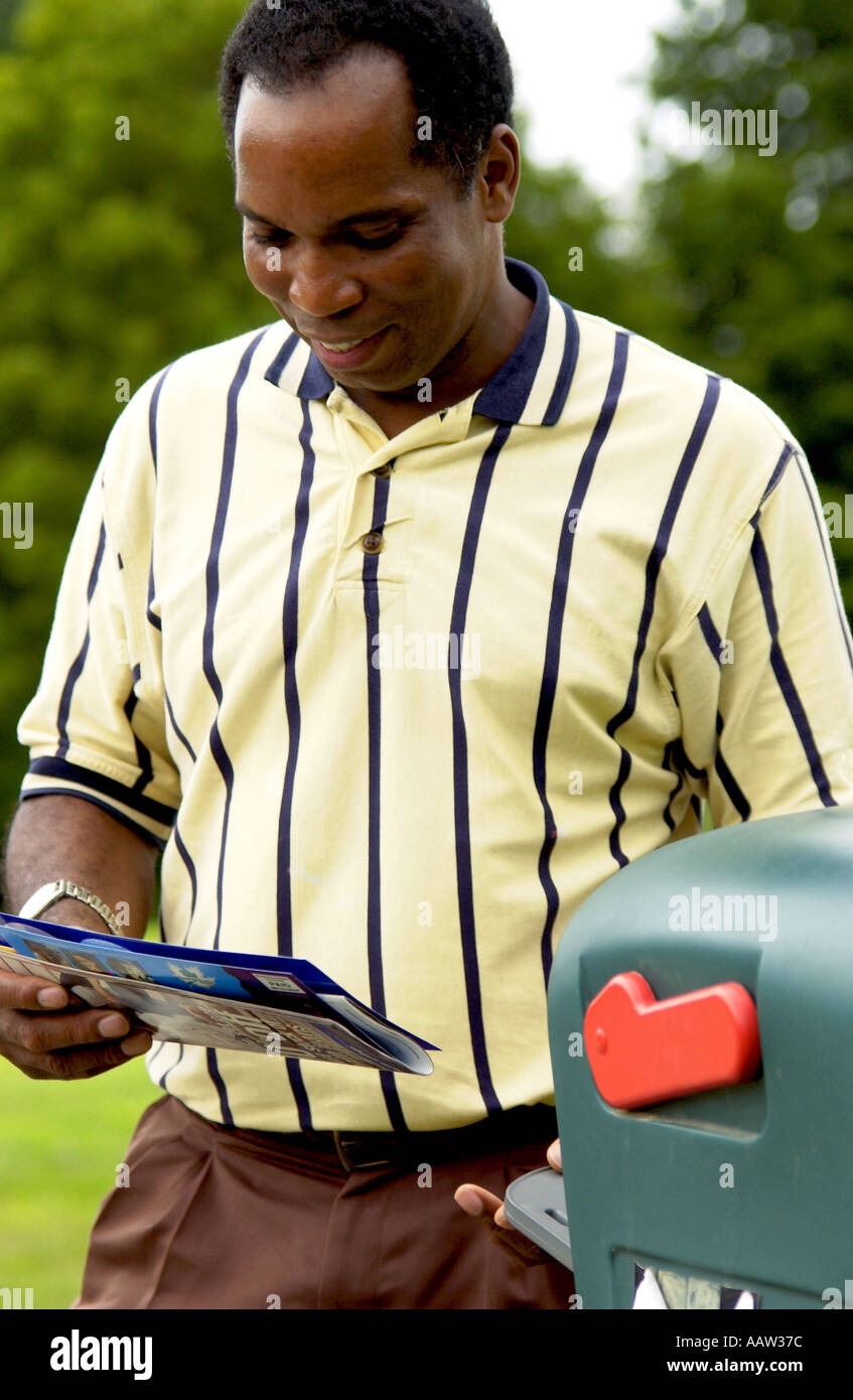 African American man getting mail from mailbox Stock Photo - Alamy