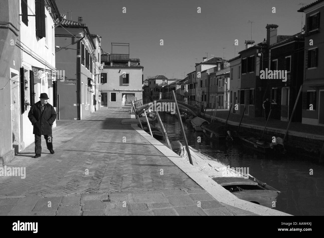 Black and white image of Borano, Italy with a local man walking down ...