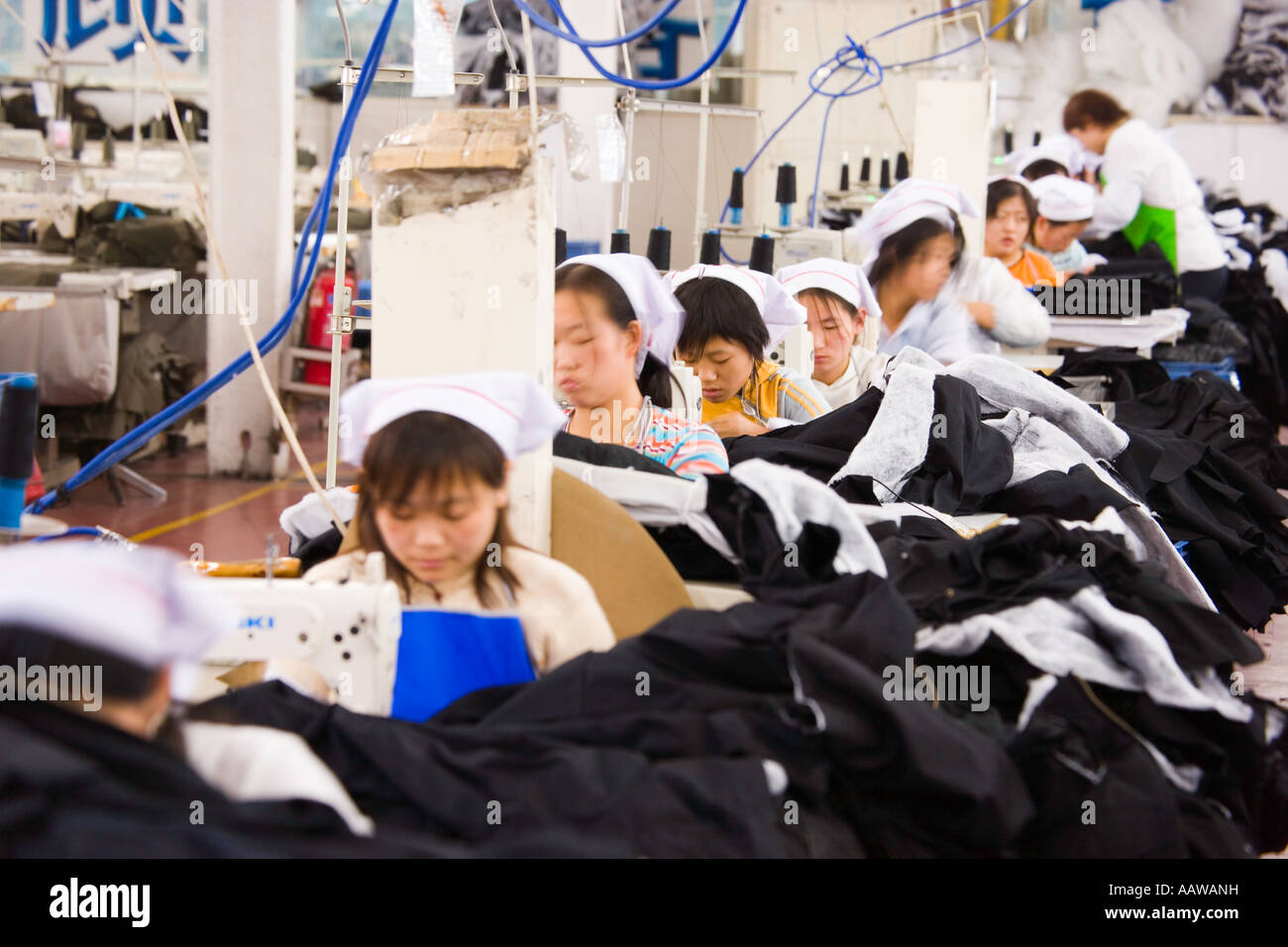 Clothing and fabric factory with handworkers and sewing machines ...