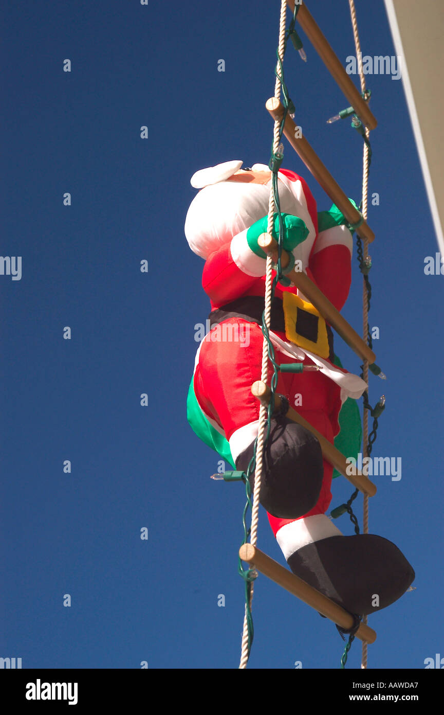 Santa Claus climbing a ladder Stock Photo - Alamy