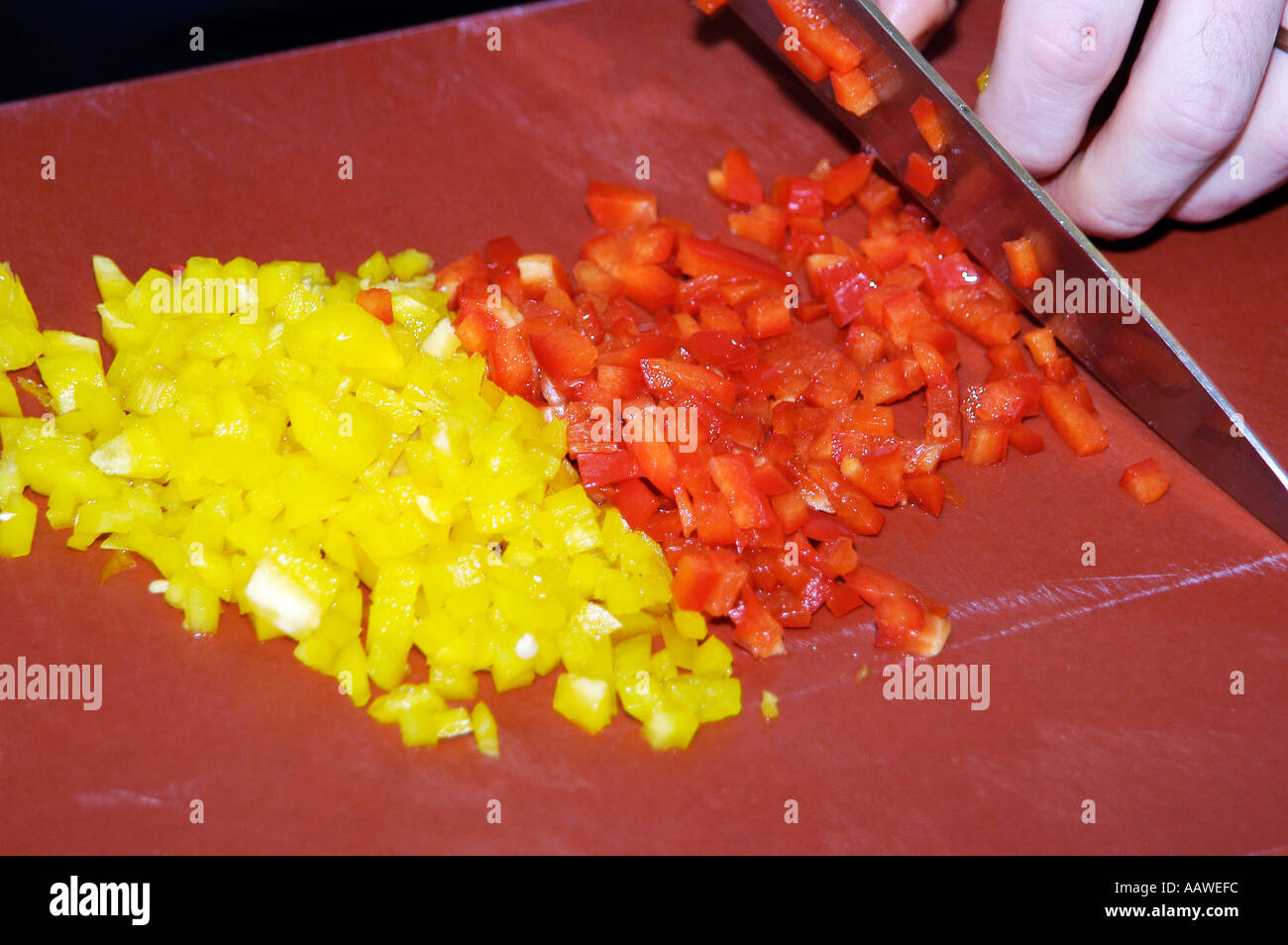 Red and yellow peppers being chopped in a kitchen Stock Photo - Alamy
