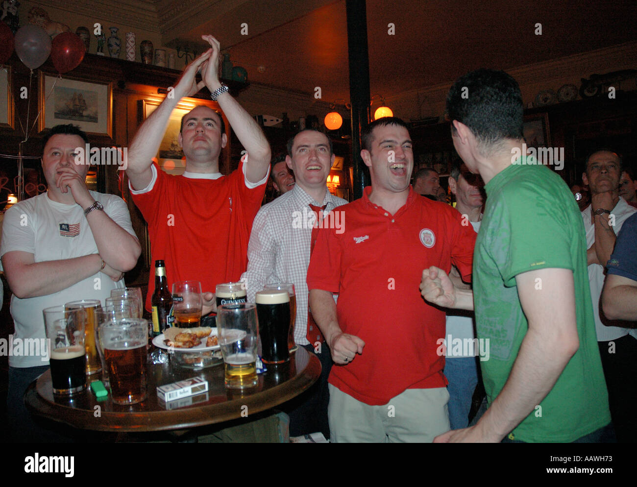 Group of Liverpool supporters watching football match in local pub ...